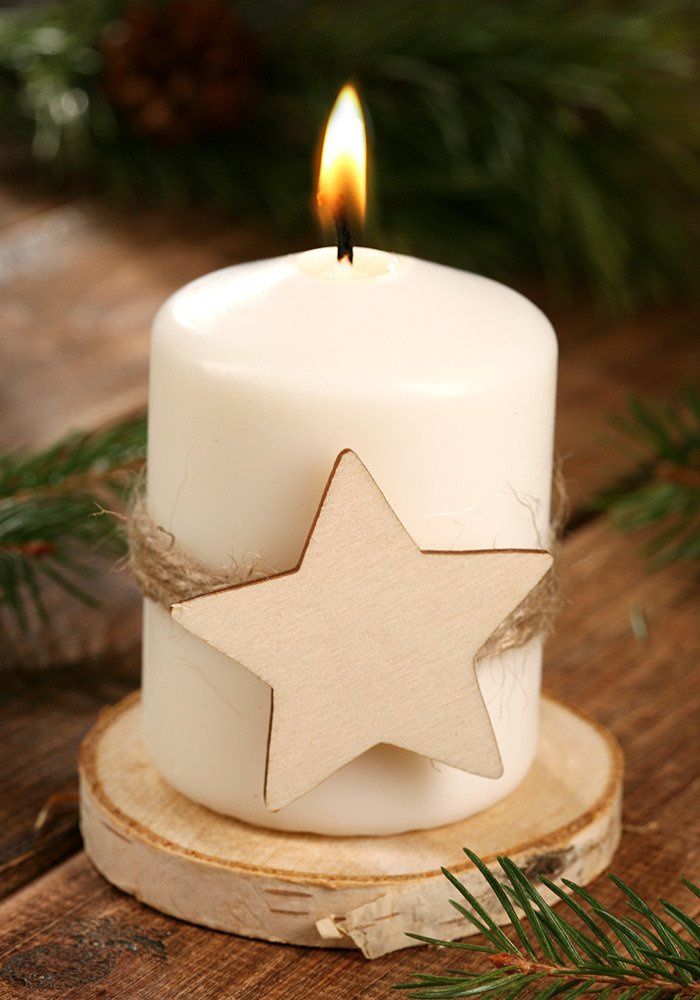 Weihnachtskerze, Kerze mit einem Stern auf einer hölzernen Scheibe ...